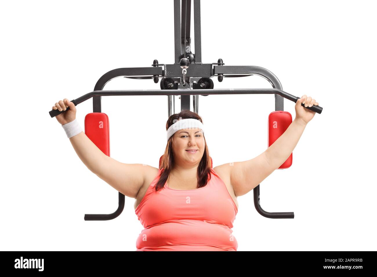 Overweight woman exercising on a fitness machine isolated on white ...