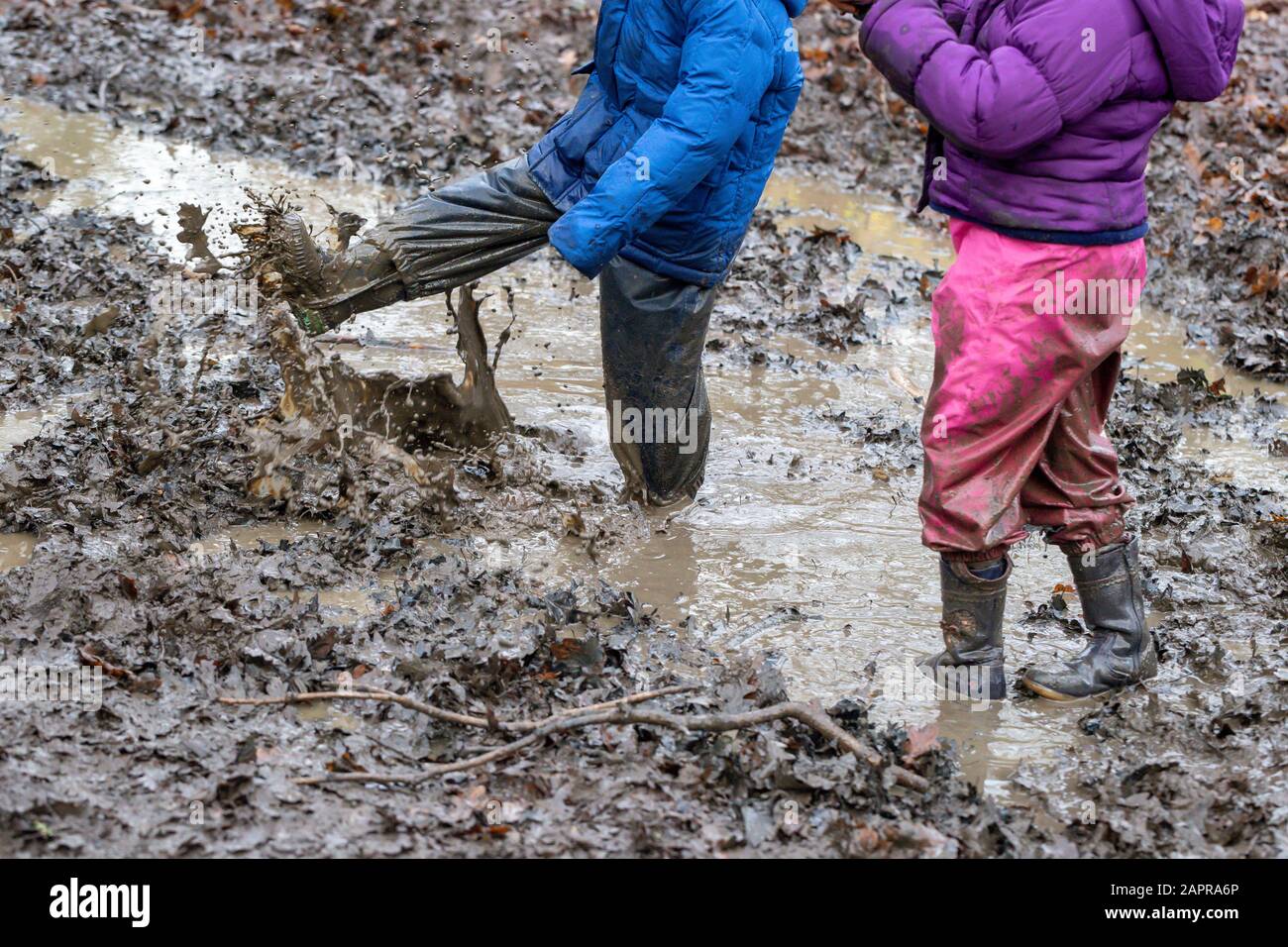 Young children playing in a muddy puddle Stock Photo - Alamy