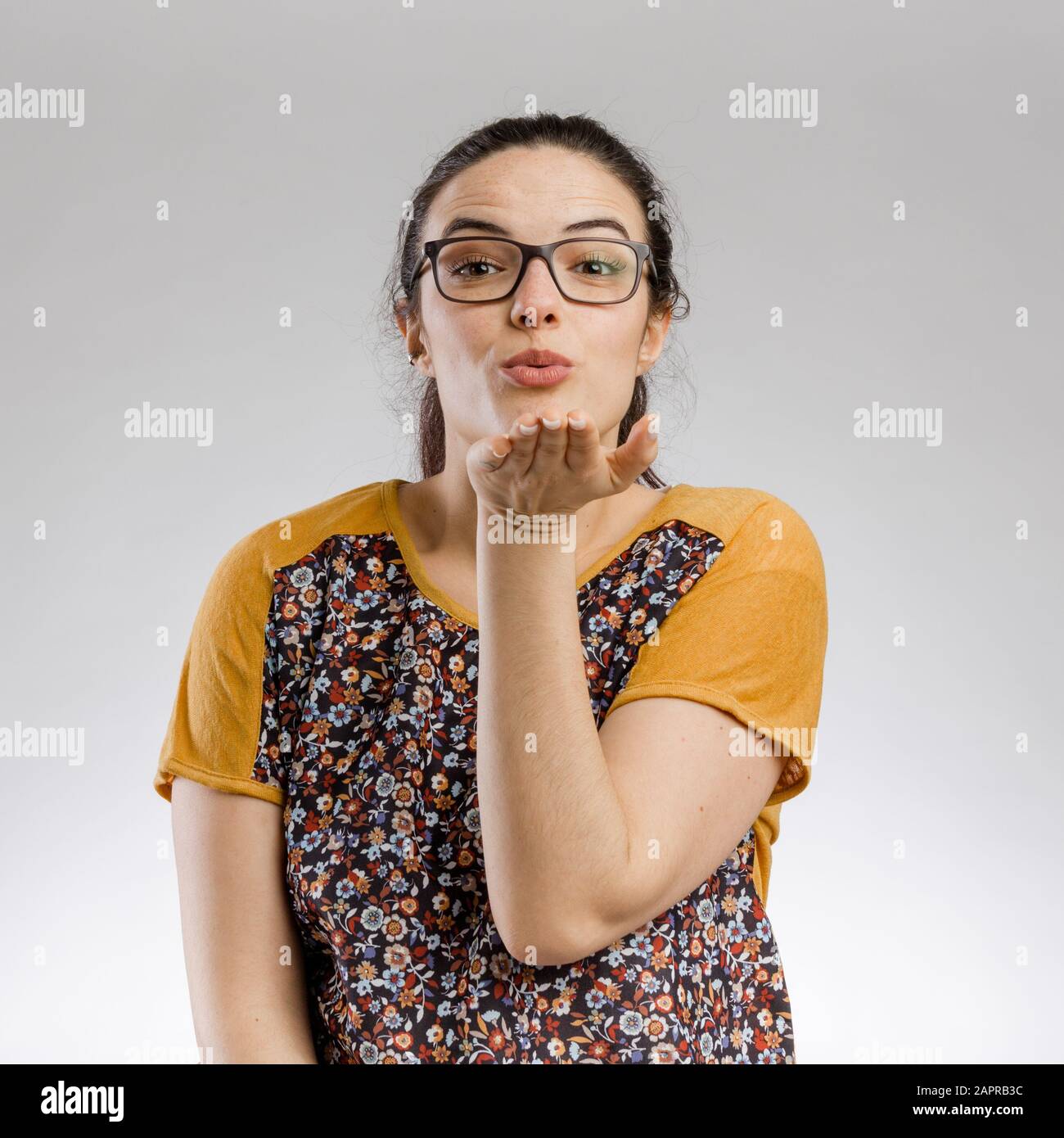 Portrait of a cute brunnet woman sending a kiss Stock Photo - Alamy