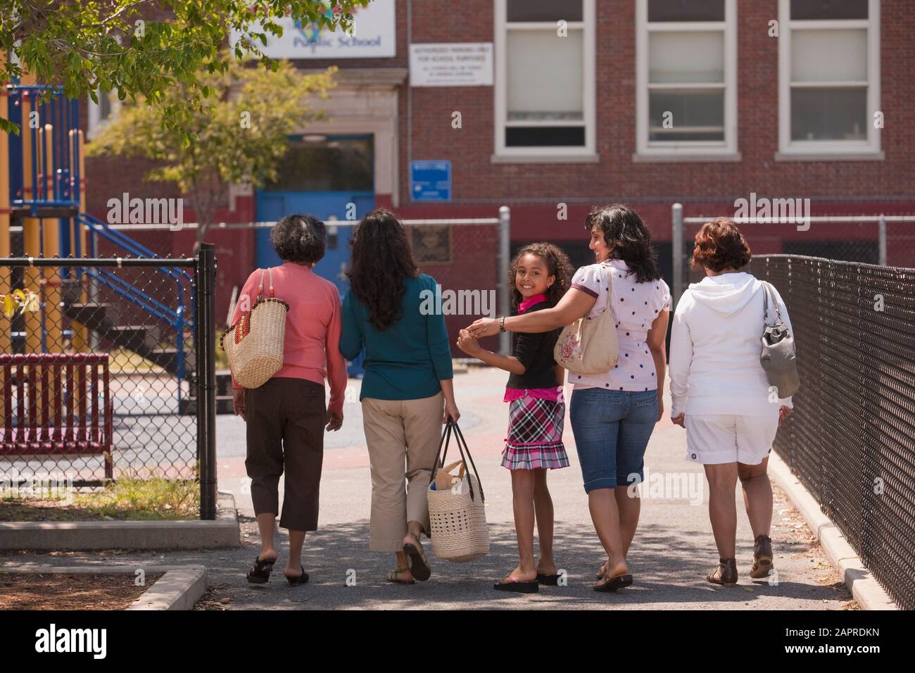 A group of women over three generations walking together in a row down ...