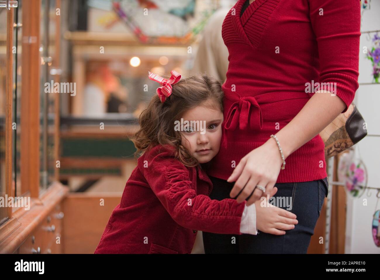 Young girl clinging to her mother Stock Photo - Alamy