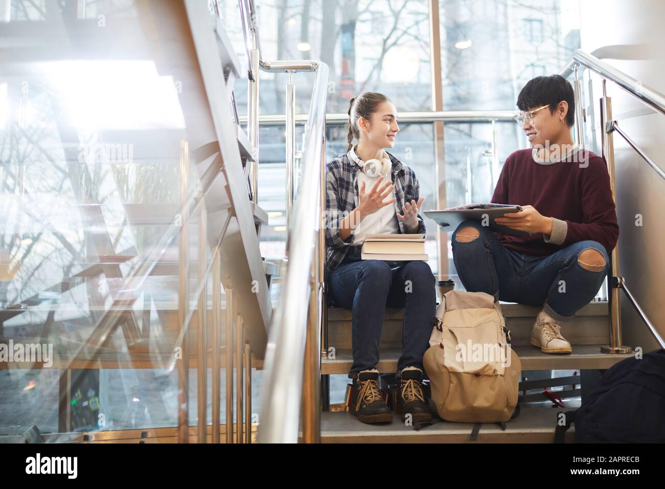 Two women sitting on stairs hi-res stock photography and images - Alamy