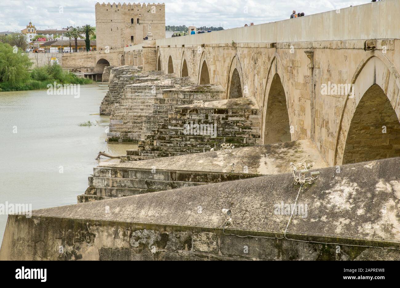 Beautiful view of an old bridge with arcs underneath and a lake in the ...