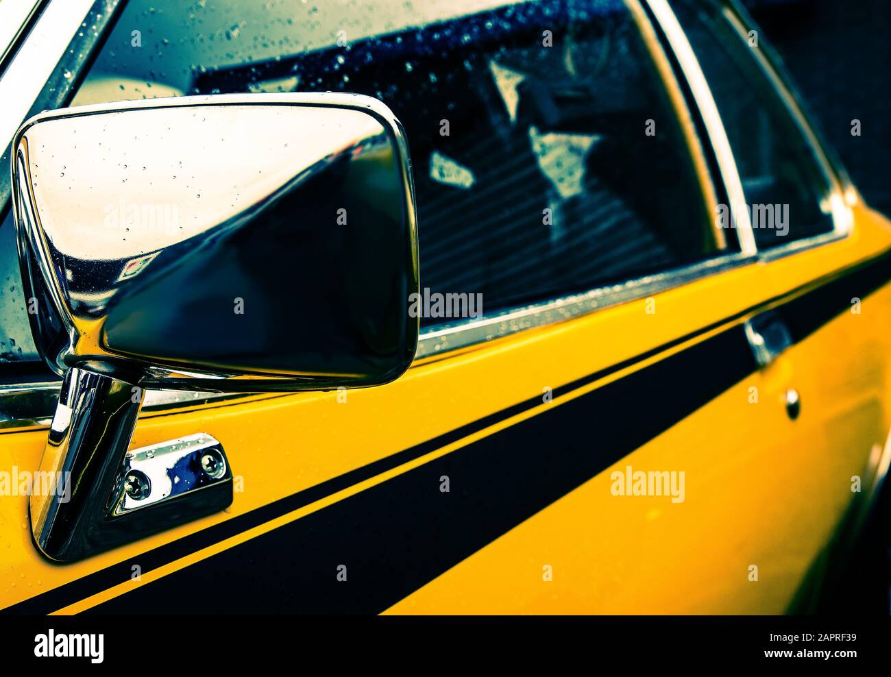Closeup shot of the side of a yellow car with a black line under the ...