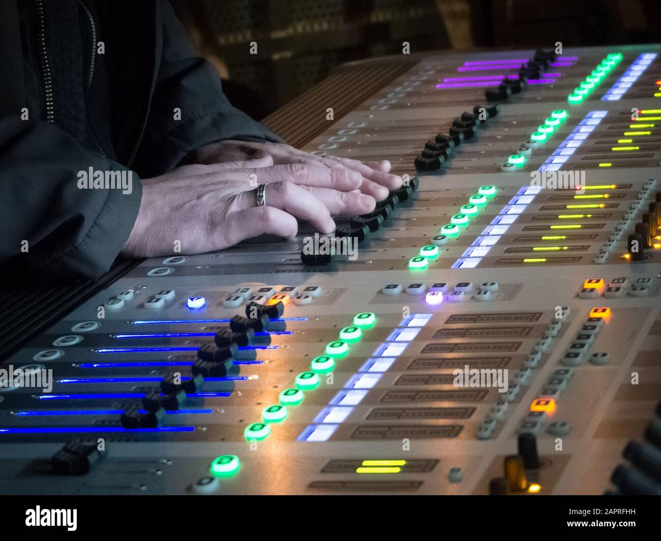 Person controlling the control panel of a digital studio mixer at a ...