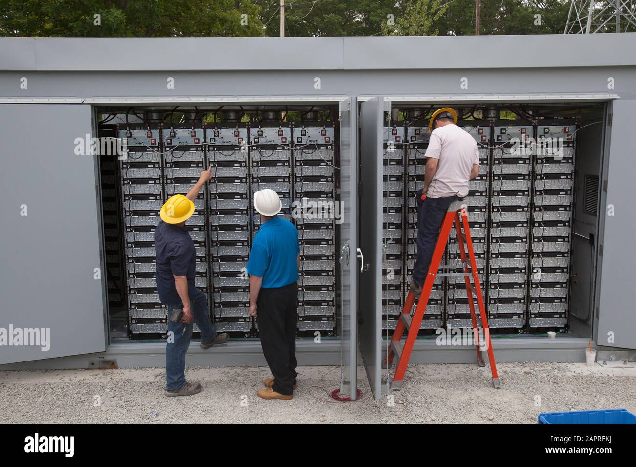 Tradesmen working on electrical components outside Stock Photo - Alamy
