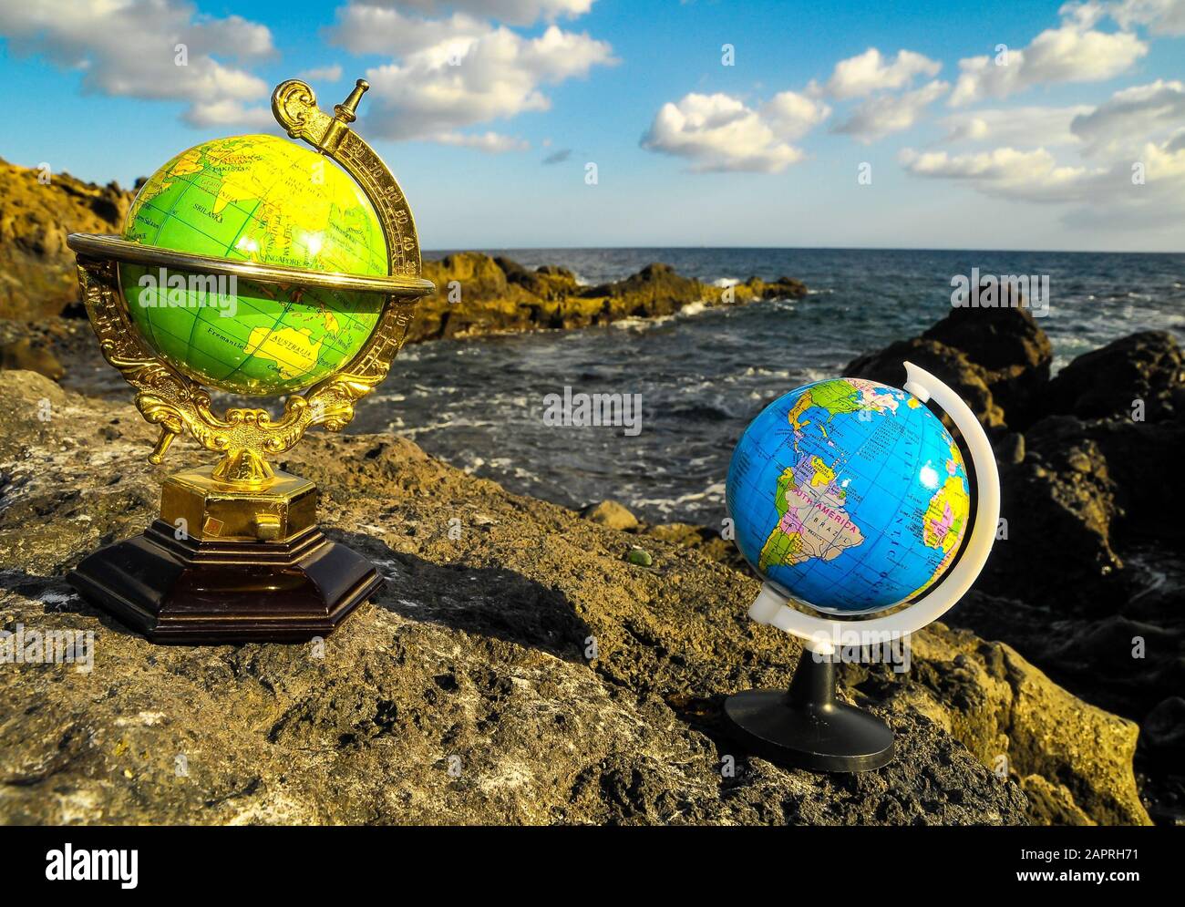 Shallow focus shot of two 3D globe model with a blurred ocean in the ...