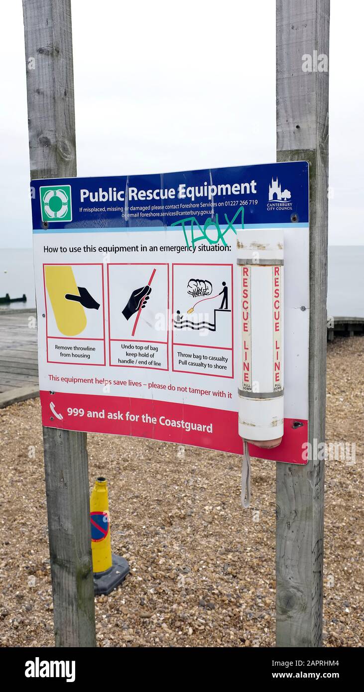 Public rescue equipment sign which has graffiti on it, on the beach in ...