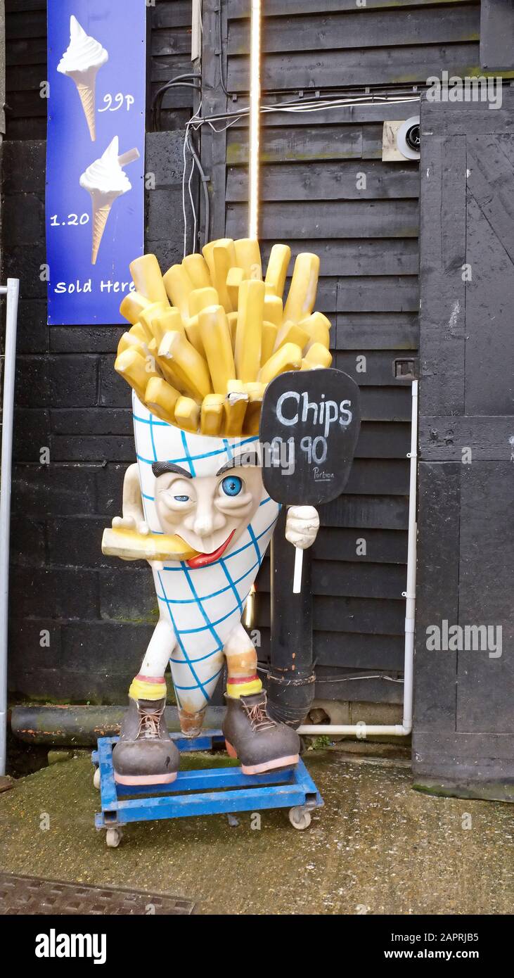 Large plastic chip shop sign with a cartoon face and a sign for chips £ ...
