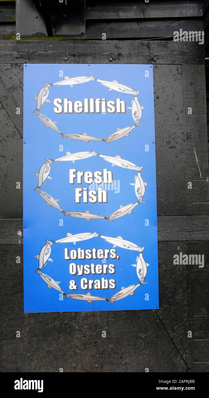A blue sign outside of a fish market telling the passerby's what fish ...
