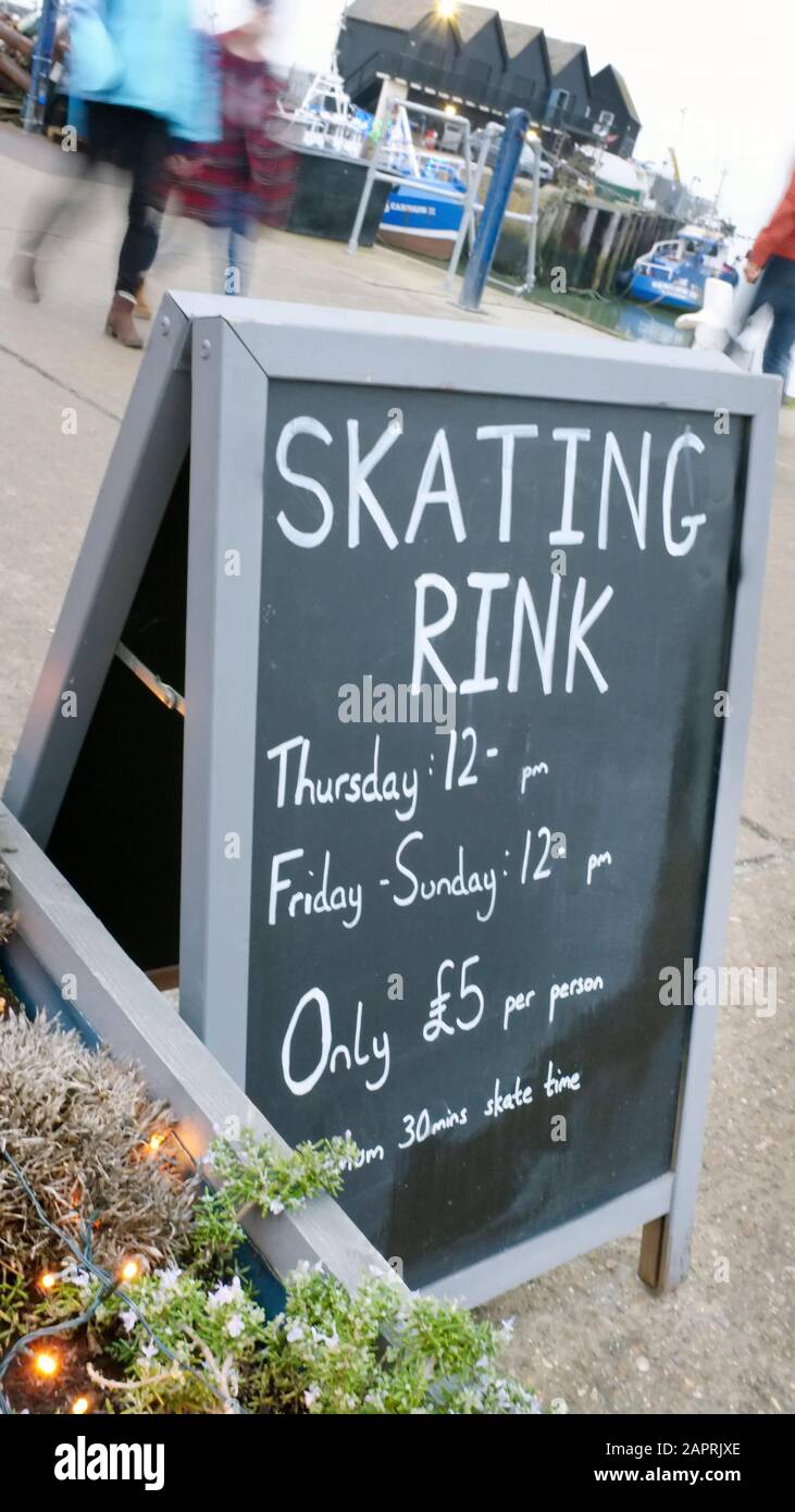 A winter ice skating sign showing the times and prices Stock Photo - Alamy