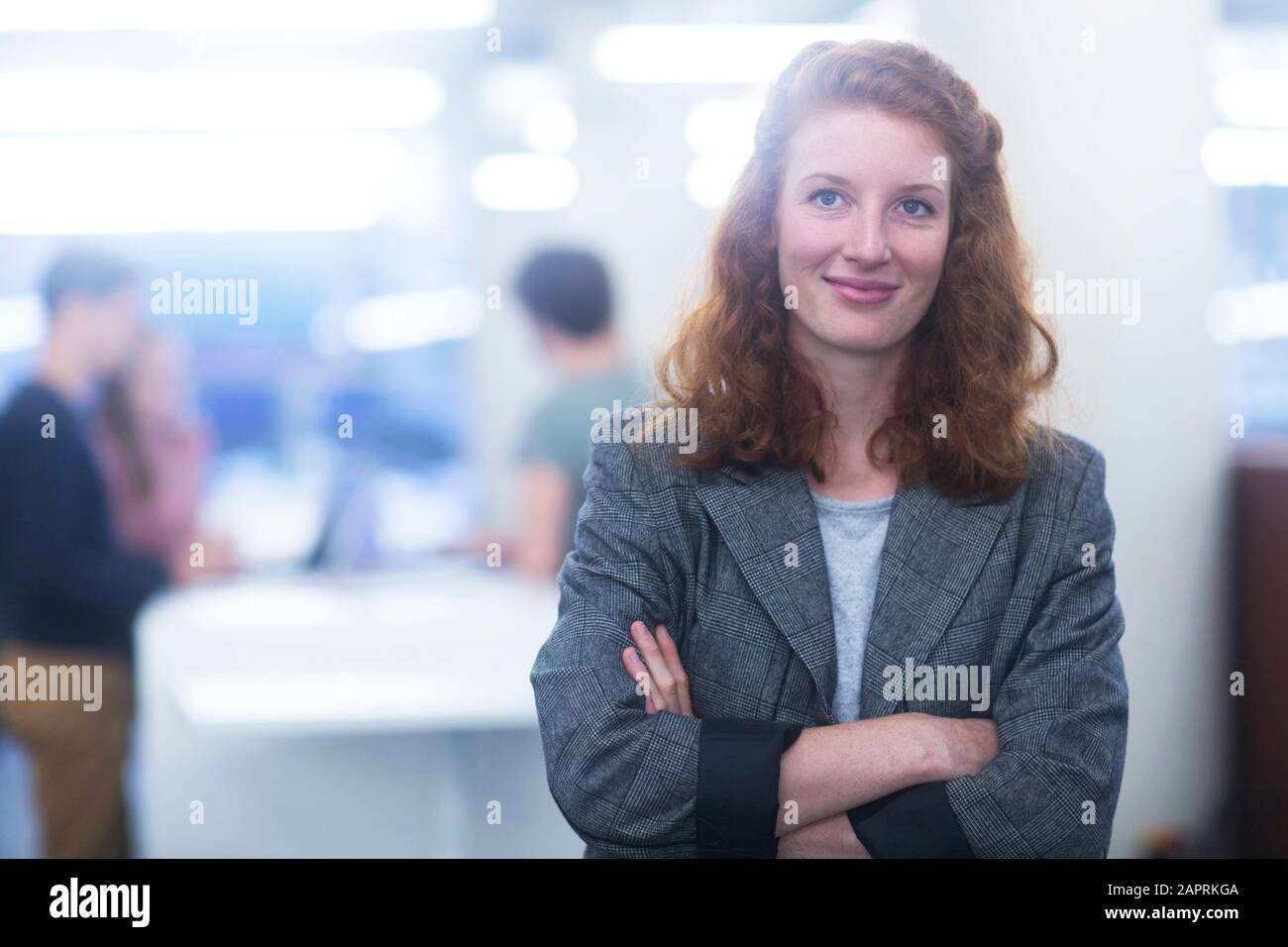 employee in an office standing with crossed arms Stock Photo - Alamy