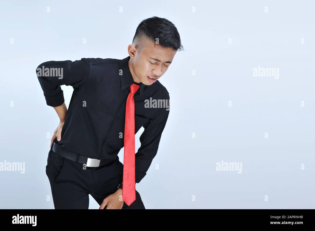 Young asian business man having back pain over grey background Stock ...