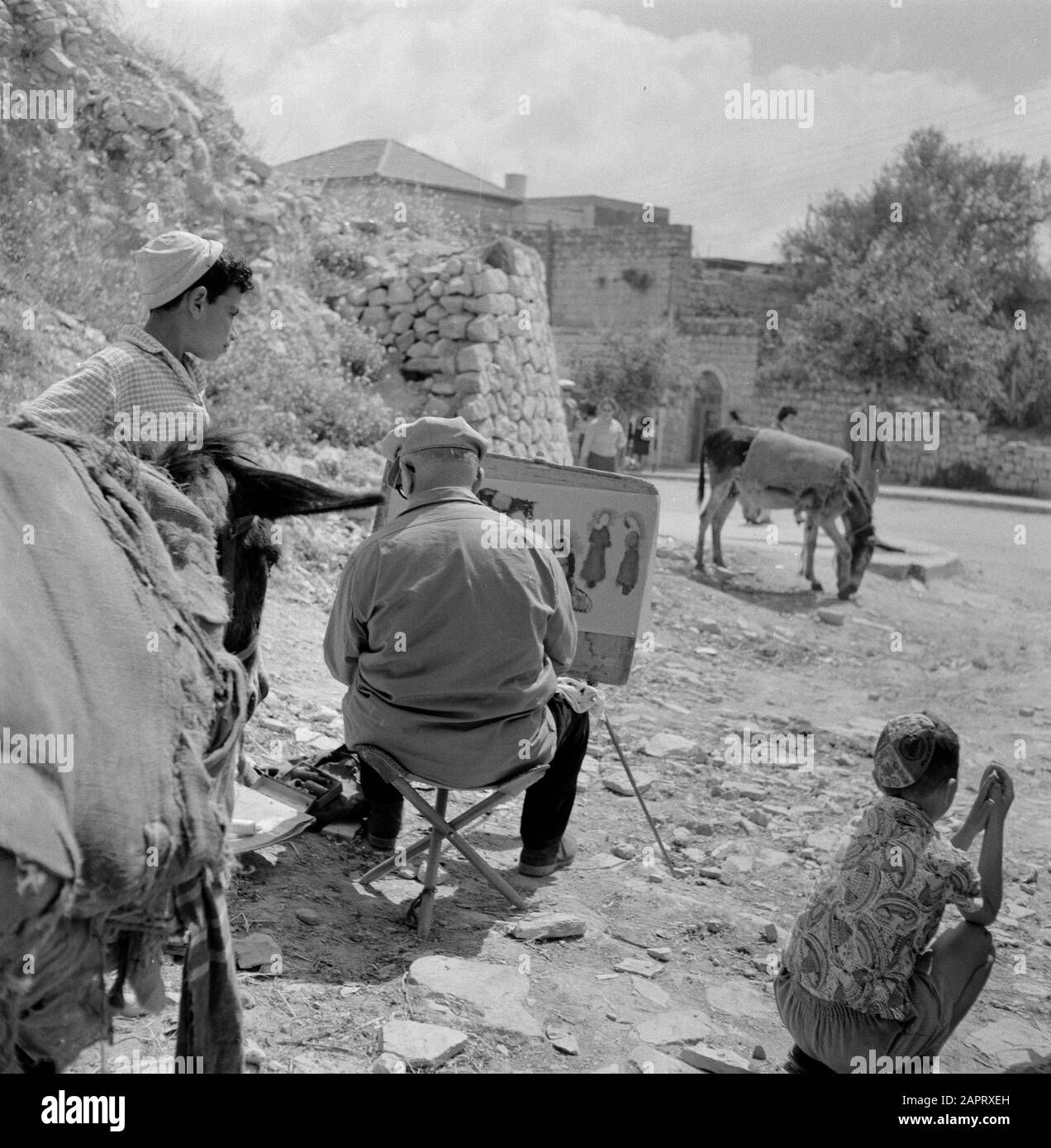 An artist at work on the street in Safad (Safed). Two little boys with ...