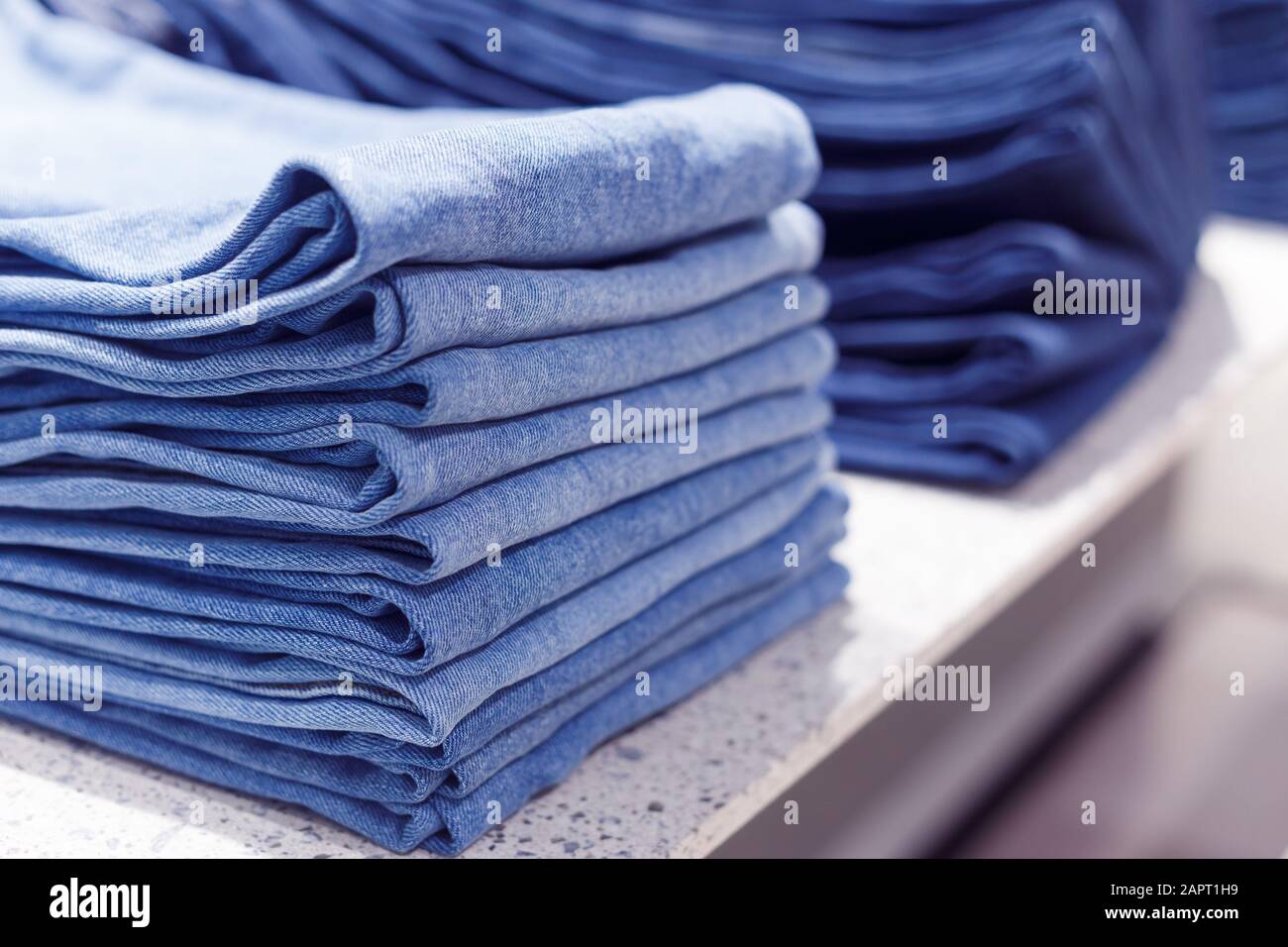 Stacks of blue jeans pants on a shelf in shop Stock Photo - Alamy