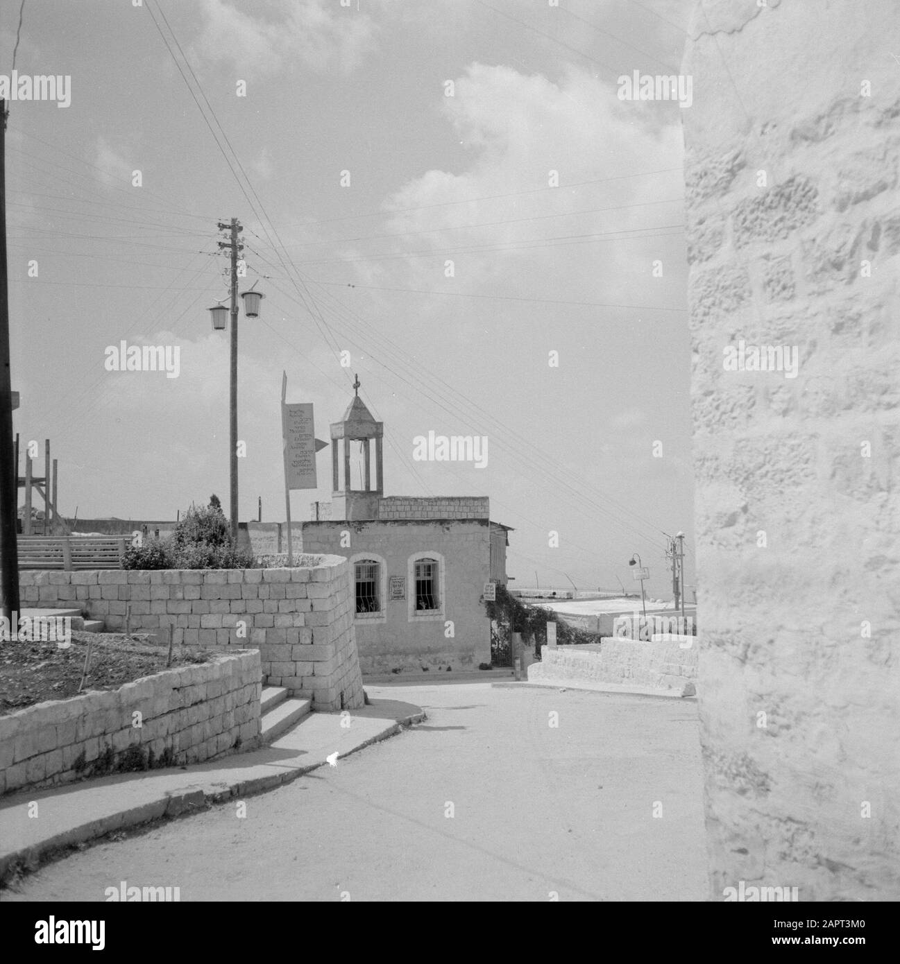 Some buildings and an open church turret with cross, in the artists ...