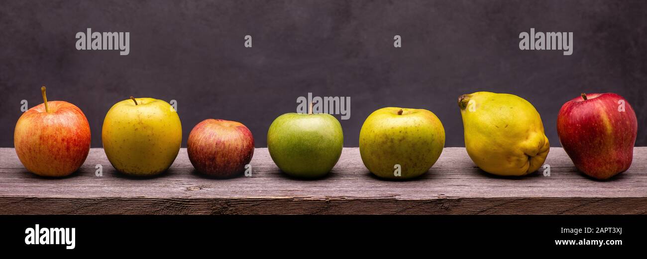 on the rough wooden table, seven apples of different types Stock Photo ...