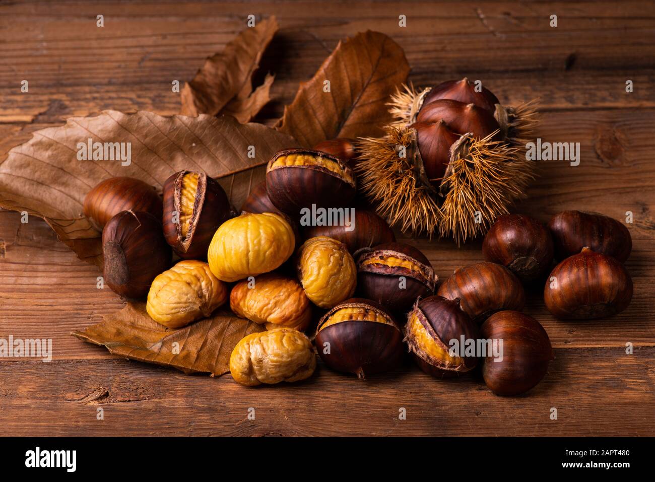 on the rustic wooden table a pile of fresh and roasted chestnuts Stock ...