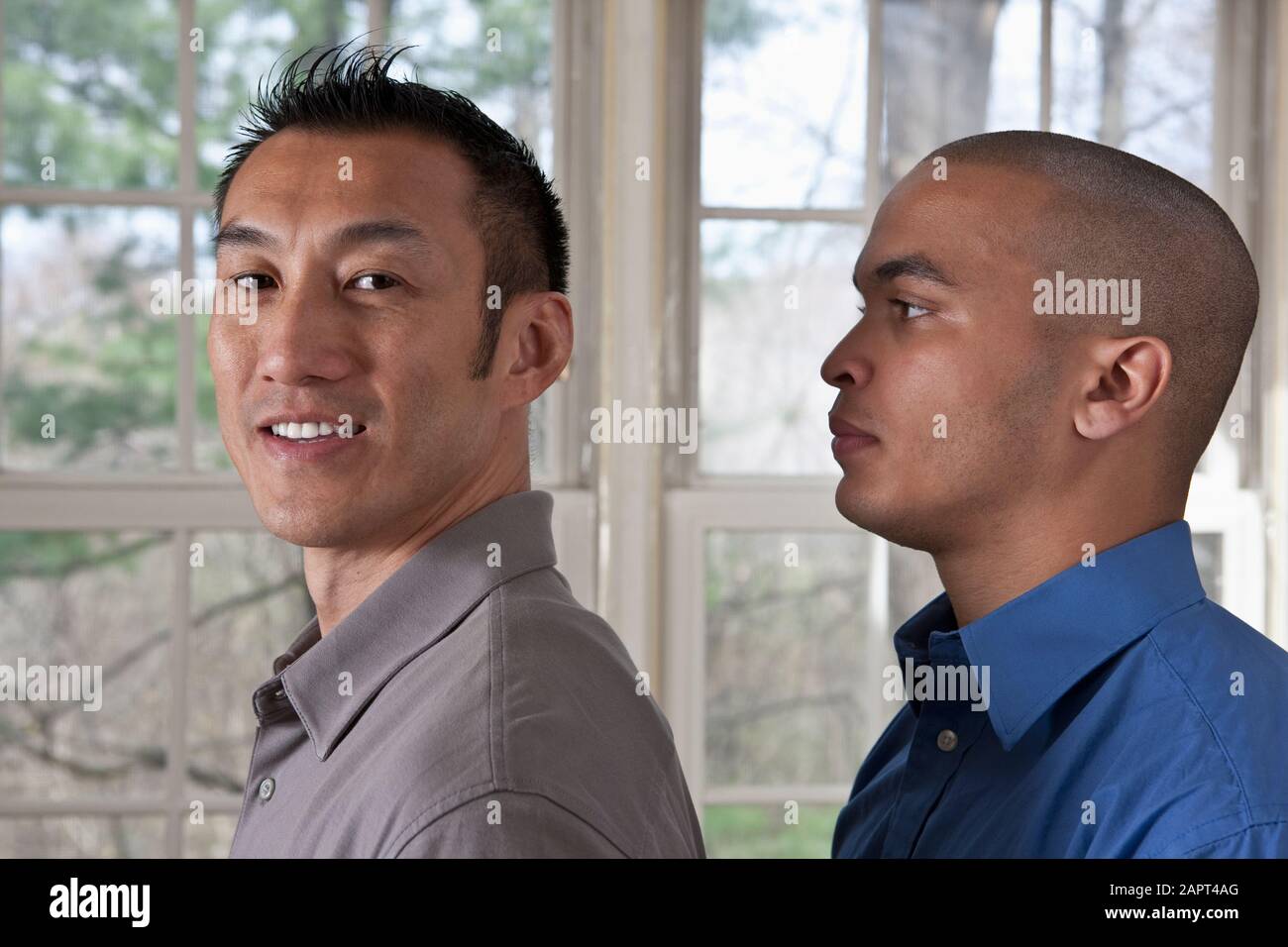 Portrait of the side view of two young businessmen standing facing left ...
