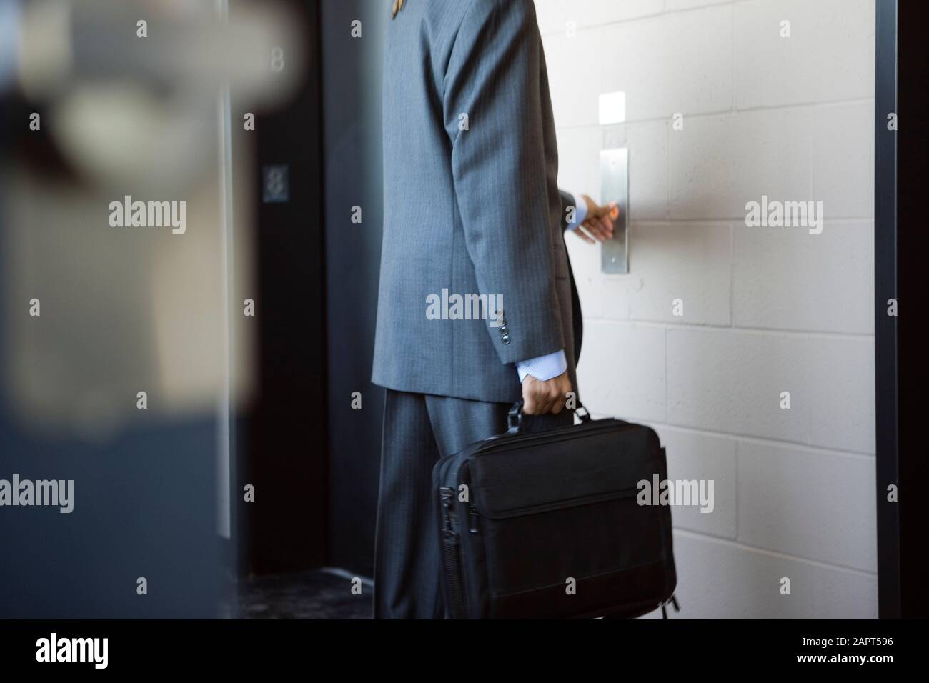 A young Business man pushing button of an elevator Stock Photo - Alamy