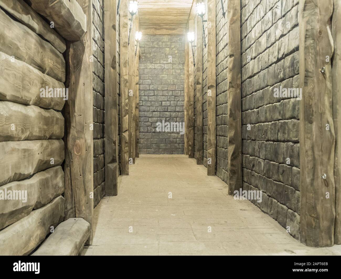Stone corridor with wooden columns and lamps on the walls like in a ...