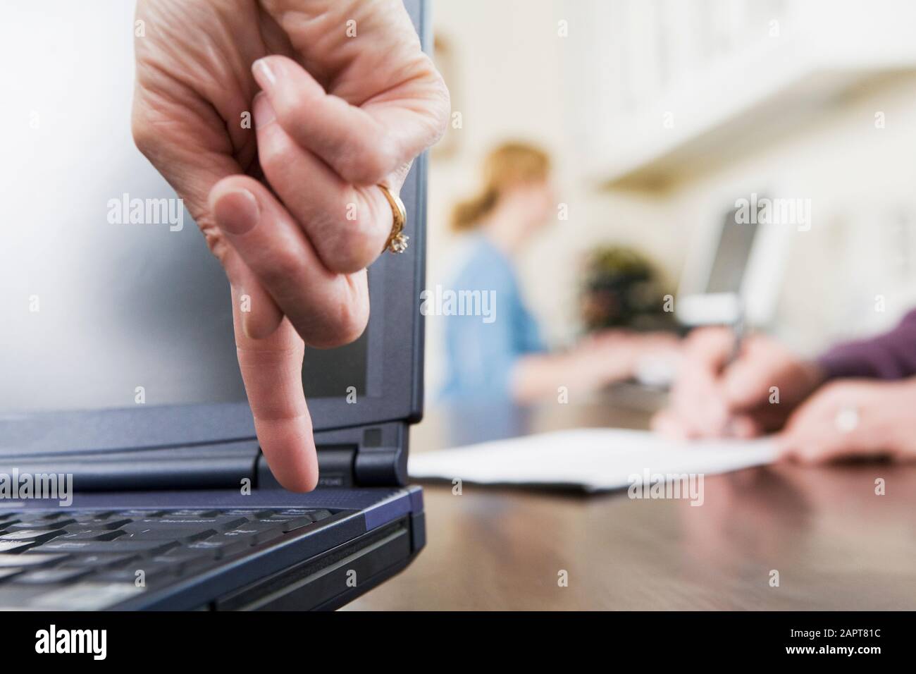A woman's finger pointing downwards towards a key on a laptop keyboard ...