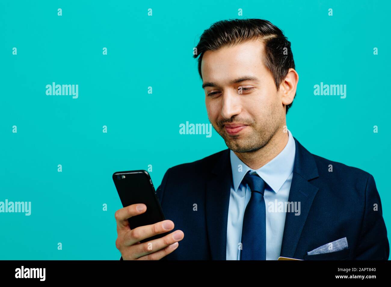Portrait of a young entrepreneur business man smiling, looking at phone ...
