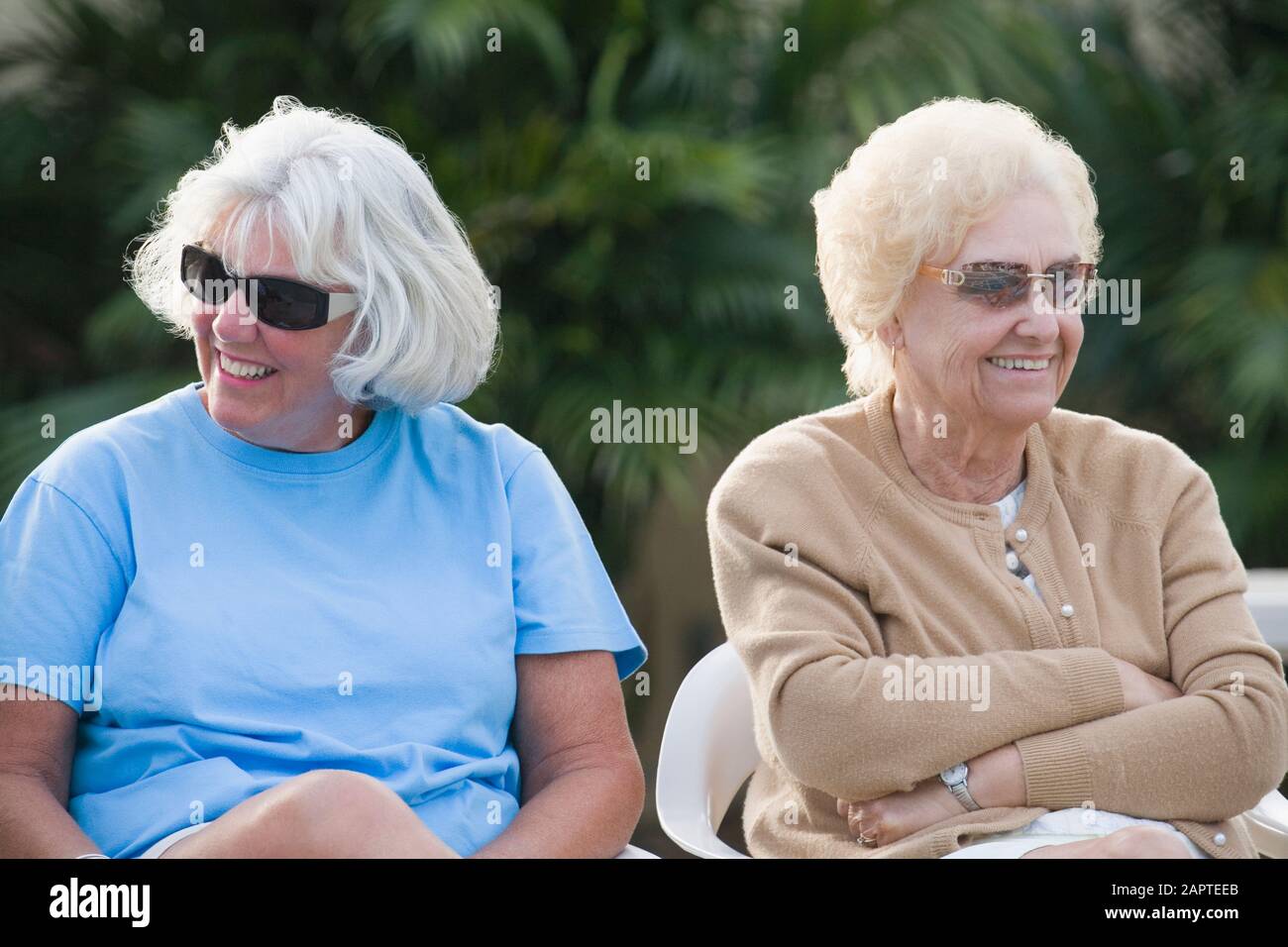 Two senior women sitting together and smiling Stock Photo - Alamy