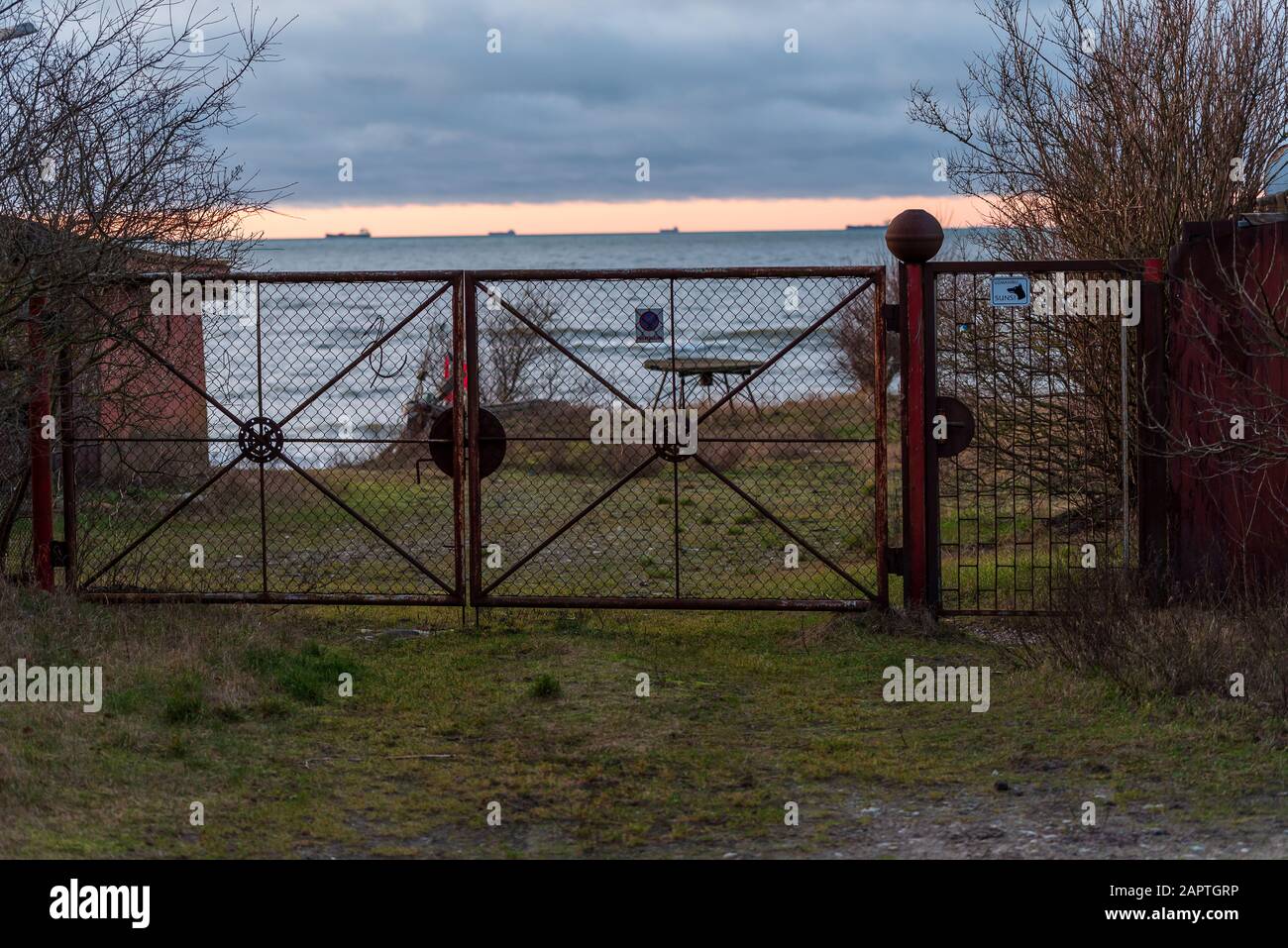 the road to the sea ends at a locked ancient metal gate, behind which ...