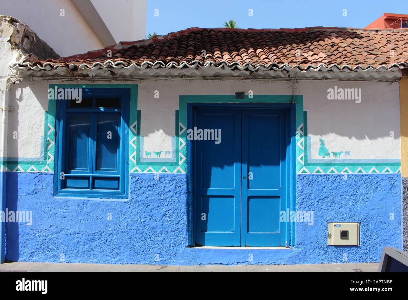 Small house with blue painting, blue door, blue window and old tiled ...