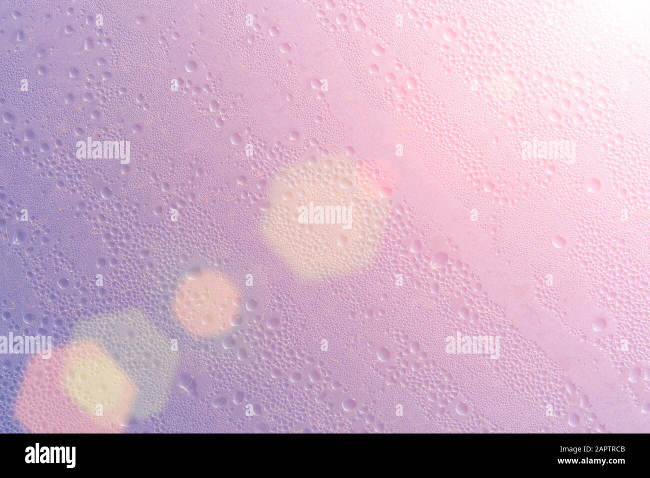 Background texture wet pink glass with drops in sun and lens flare ...