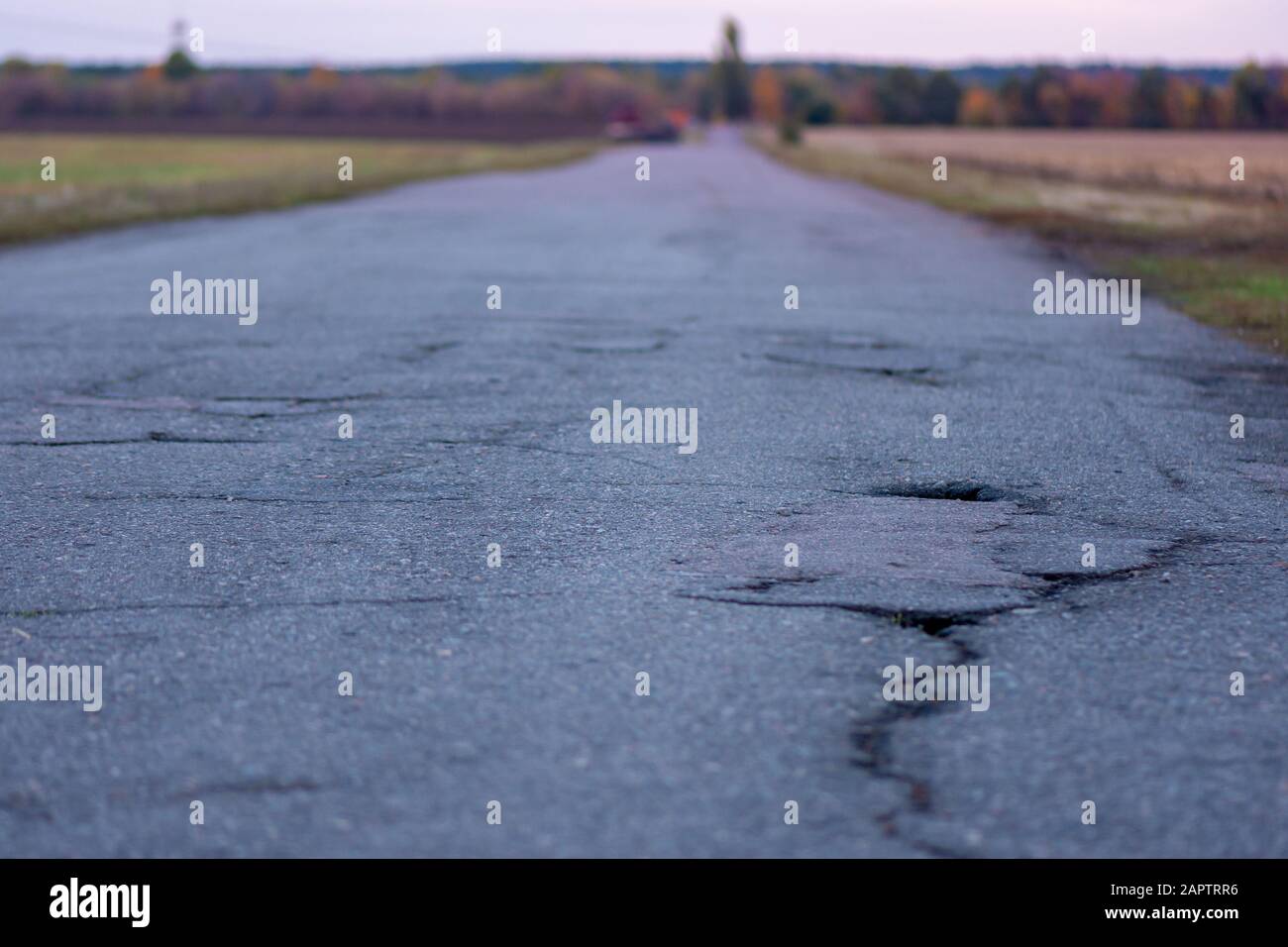 background texture of a crack on a road surface close-up in the sun ...