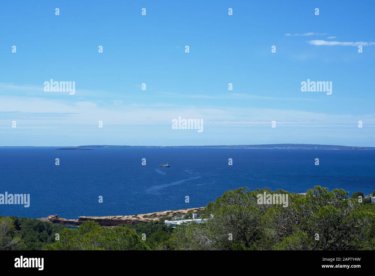Beautiful Balearic sea coast with trees, clean blue water and cloudy ...