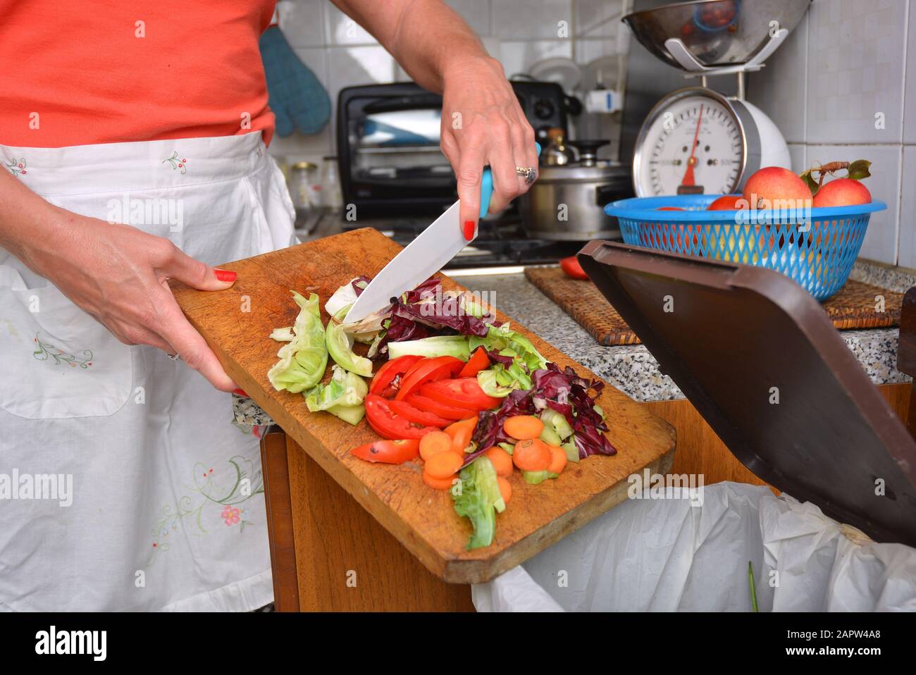 Detail of a female hand disposing of organic waste in a proper bin with ...