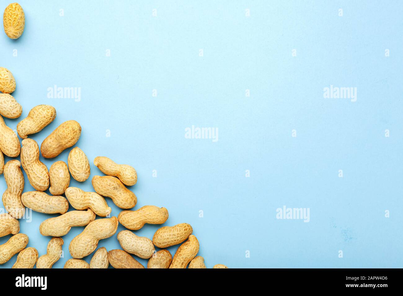 Frame made of nuts peanuts in shell with copy space on blue colored ...