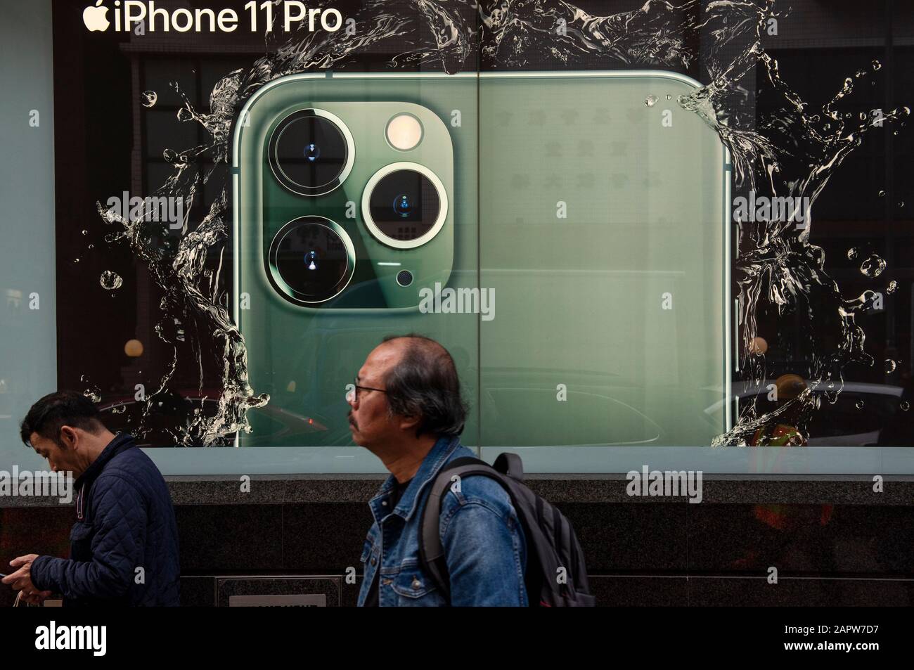Pedestrians walk past an Apple Iphone advertisement in Hong Kong Stock ...