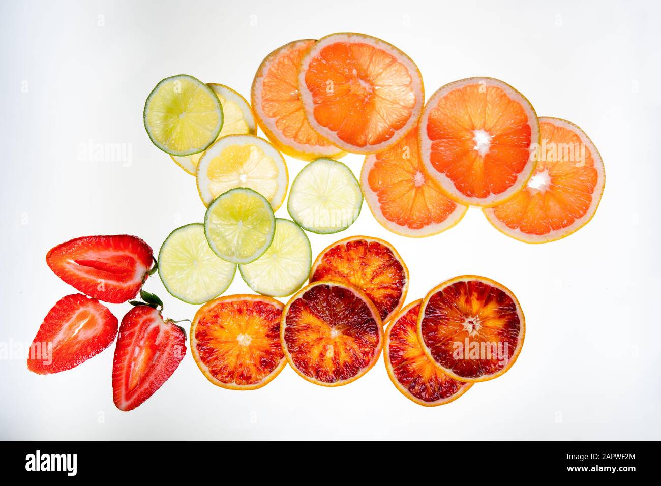 Slices of citrus cut rounds and strawberries on white background Stock ...