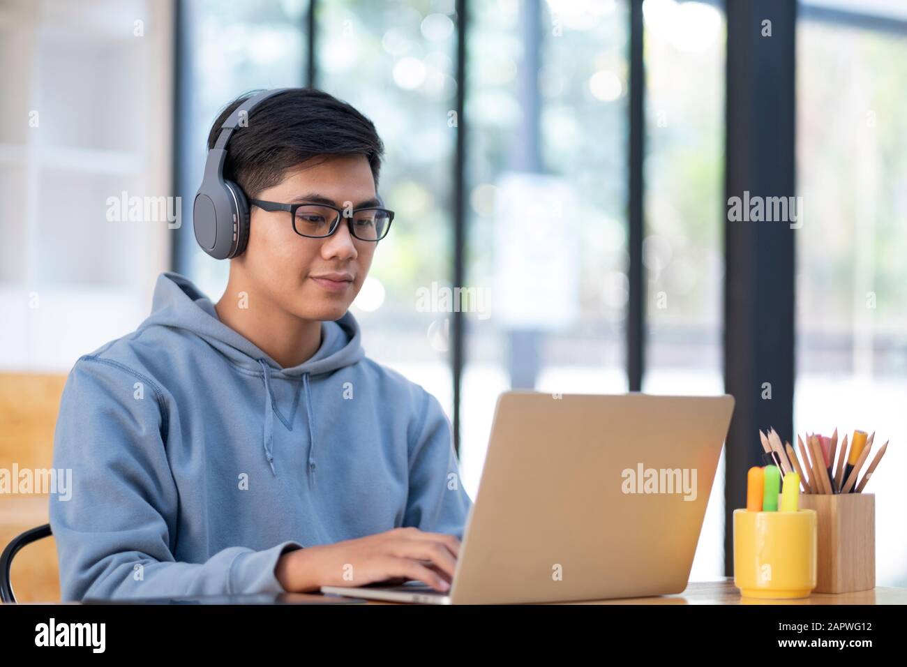 Young collage student using computer and mobile device studying online ...