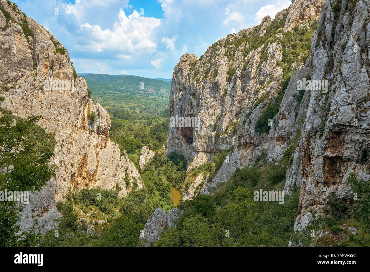 Landscape of rocks covered in greenery under a blue sky and sunlight ...