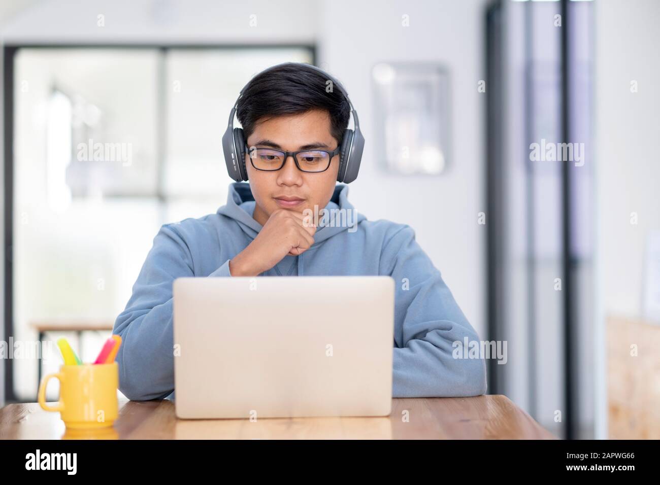 Young collage student using computer and mobile device studying online ...