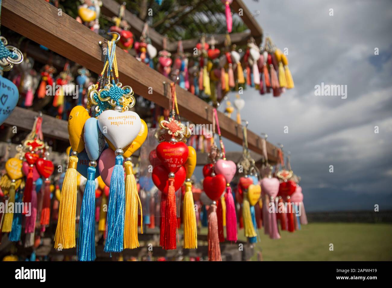 Colorful prayer ribbons with hearts, hanging from a wooden structure ...