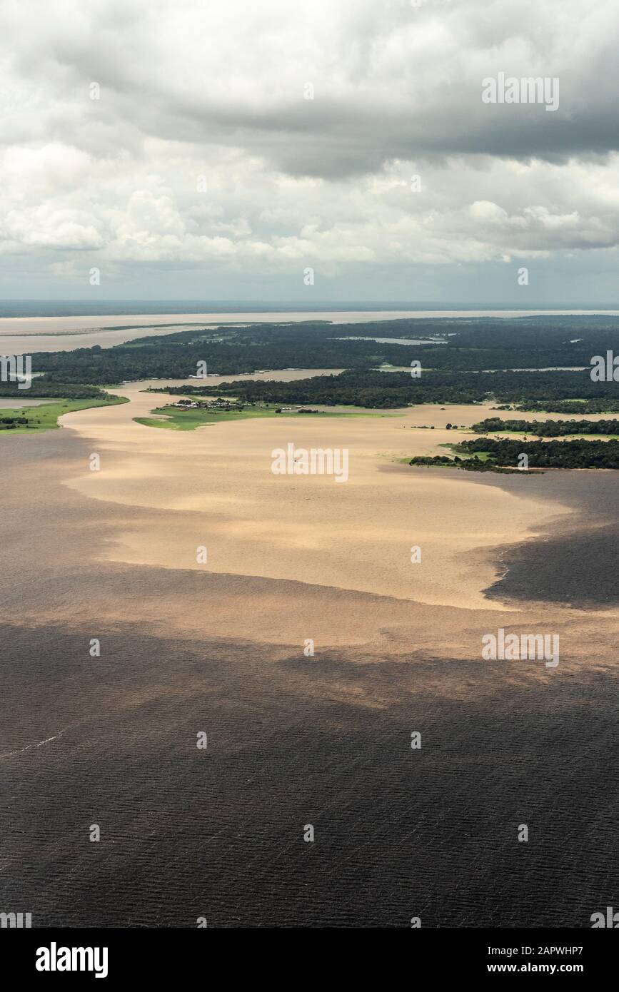 Aerial view to the meeting of muddy and dark waters in Amazon River ...