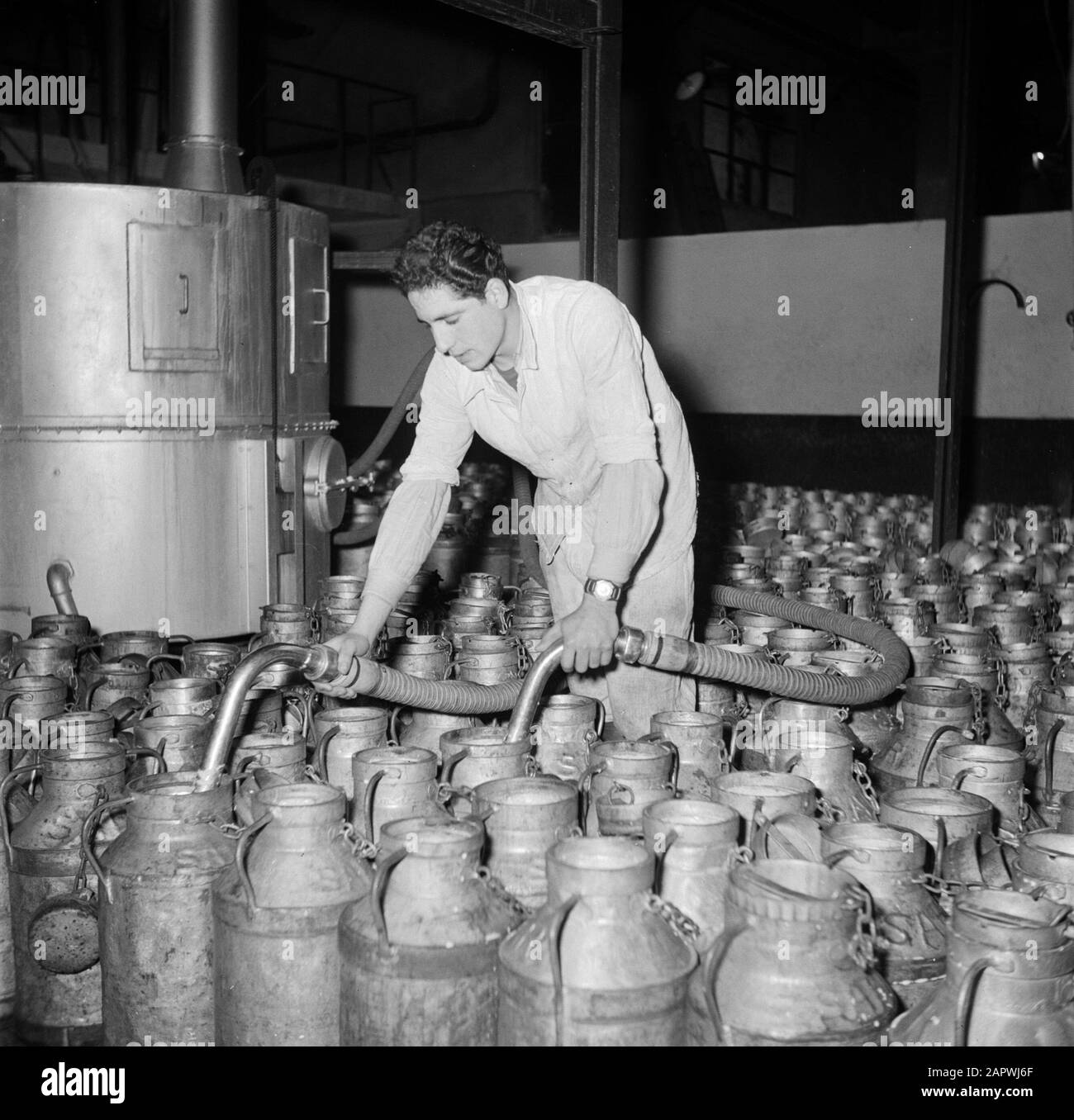 Reportage Paris Milk factory: man fills the milk cans Date: 1950 ...