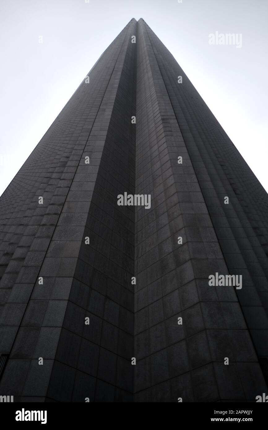 Low angle vertical greyscale of a high-rise stone building under the ...