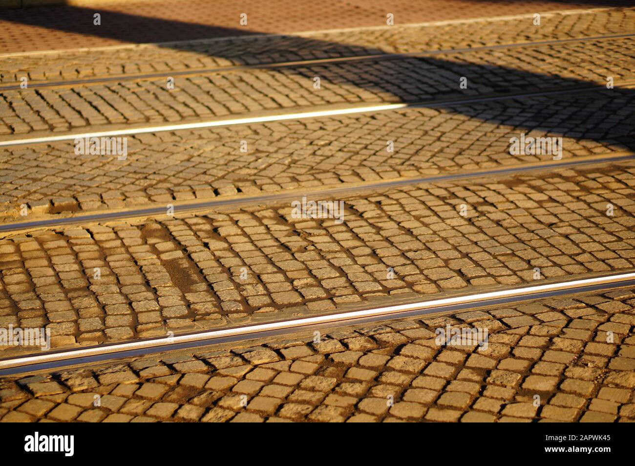 Train tracks on a cobblestone road at daytime Stock Photo - Alamy
