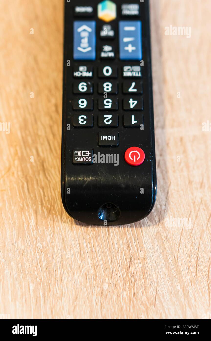 Vertical high angle closeup shot of a remote controller on a wooden ...