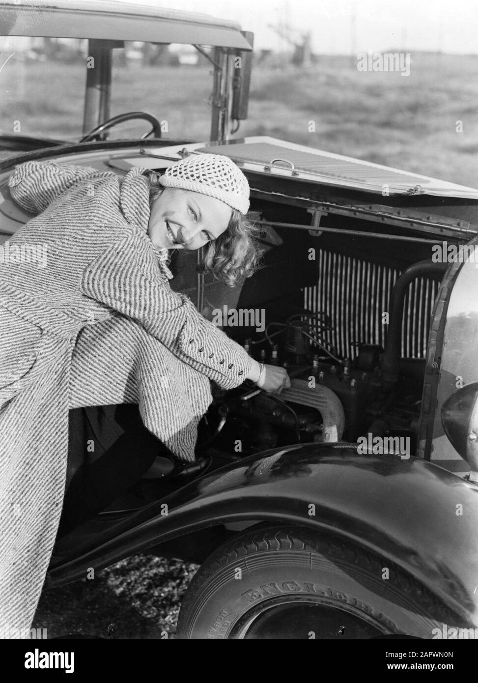 Reportage model Model Eva Waldschmidt looks under the hood of a car ...