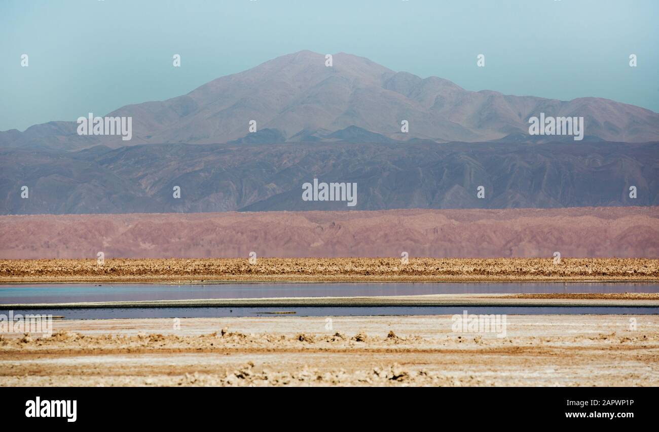 Heat haze shimmers over salt lagoons below a volcano at Salar de ...