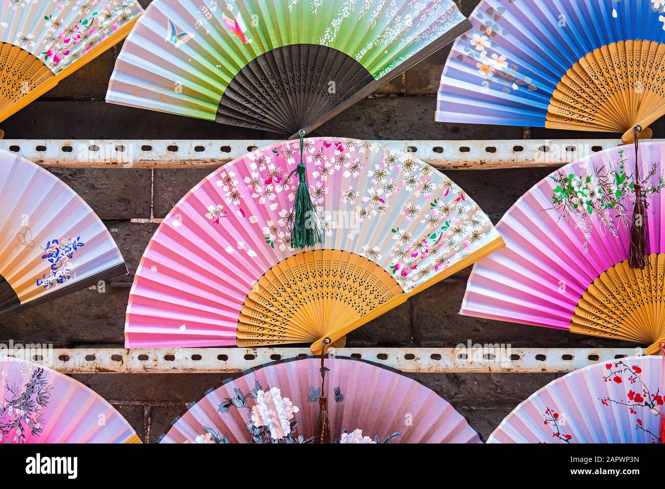 Closeup shot of several hand fans of multiple colors put next to each ...