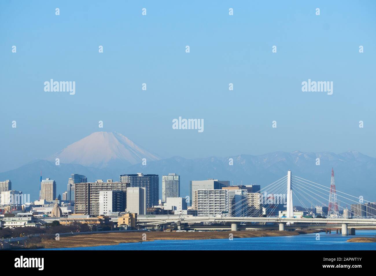 A snowy Mount Fuji (Mt. Fuji) towers in the distance over the Tokyo ...